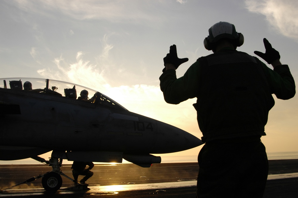 DVIDS - Images - A Navy flight deck crewman directs the pilots of an F-14 Tomcat aircraft.